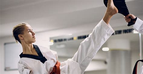 헬스 클럽에서 코치와 함께 하이킥을 연습하는 장애를 가진 단호한 태권도 선수 사진 Unsplash의 동기 이미지