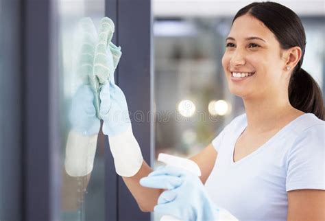 Happy Woman Cleaner And Wiping Window With Spray Bottle For