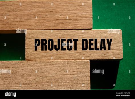 Project Delay Message Written On Wooden Block With Green Background Conceptual Project Delay