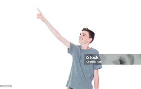 위를 올려다 보면 측면보기 전체 길이 한 남자 한 사람 1 명의 십대 소년 만 1213 세 잘 생긴 사람들 백인 남성 젊은 남자 십대 소년이 흰색 배경 앞에 서있는 가리키는