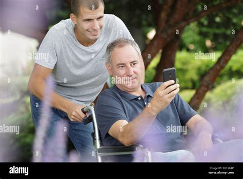 Son And Dad Sitting In His Wheelchair Taking Selfie Stock Photo Alamy
