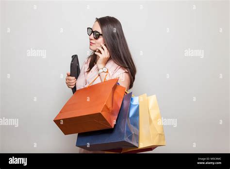 Portrait Of A Happy Girl Ordering A Taxi By Mobile Phone After Shopping