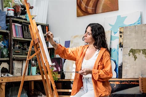 집에서 예술가의 팔레트를 들고 있는 동안 캔버스에 그림을 그리는 중년 여성 30 34세에 대한 스톡 사진 및 기타 이미지