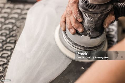 연삭기를 사용한 헤드 라이트 유리 복원 한 남자가 주유소에서 연마기로 자동차 헤드라이트의 광학 장치를 연마합니다 연마 기계로 작업하는 손 교통수단에 대한 스톡 사진 및 기타