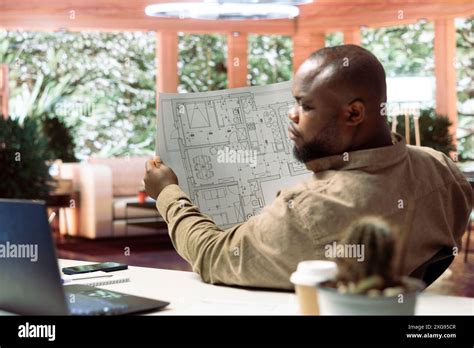 Small Business Owner Analyzing Architectural Sketches And Planning