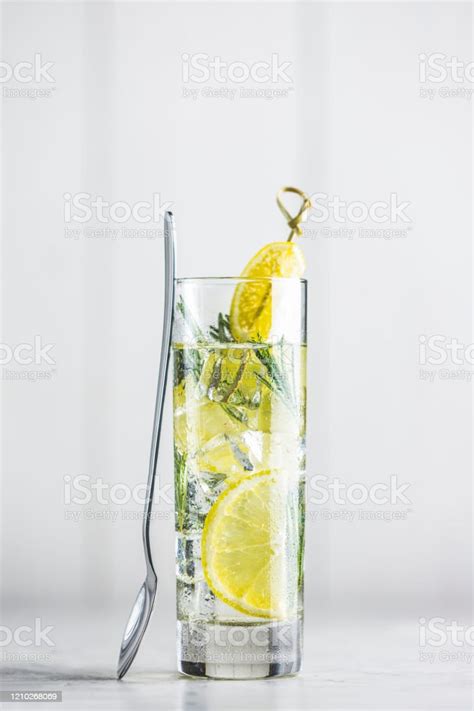 밝은 회색 배경에 유리 잔에 얼음 큐브와 상쾌한 레몬 라임 음료의 유리 로즈마리를 곁들인 여름 의 신선한 레몬 소다 칵테일 선택적인 초점 0명에 대한 스톡 사진 및 기타