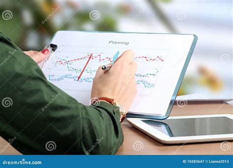Young Businesswoman Working In The Office Sitting At Her Desk Analyzing Data In Graphics