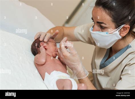 Female Physiotherapist Performing A Suction Assessment In A Newborn
