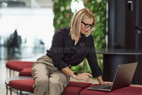 A Businesswoman Immersed In Her Work While Using A Laptop In A