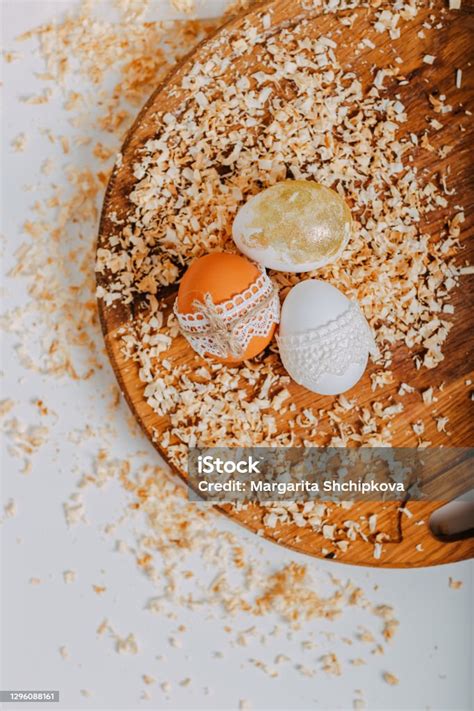 나무 배경에 톱밥이 있는 세 개의 부활절 달걀 해피 부활절 카드 레이스 테두리가 있는 부활절 달걀 흰색 테이블에 나무 도마 계란 장식 황금 부활절 달걀 0명에 대한 스톡