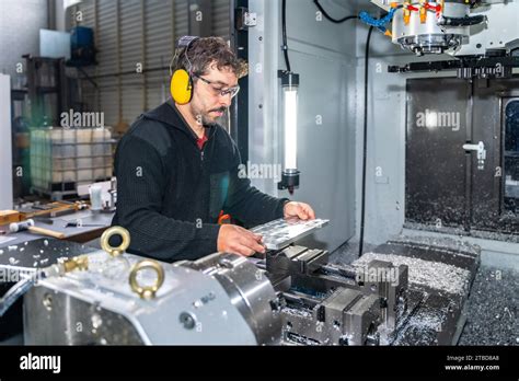 engineer working with a milling cnc machine using safety gear stock