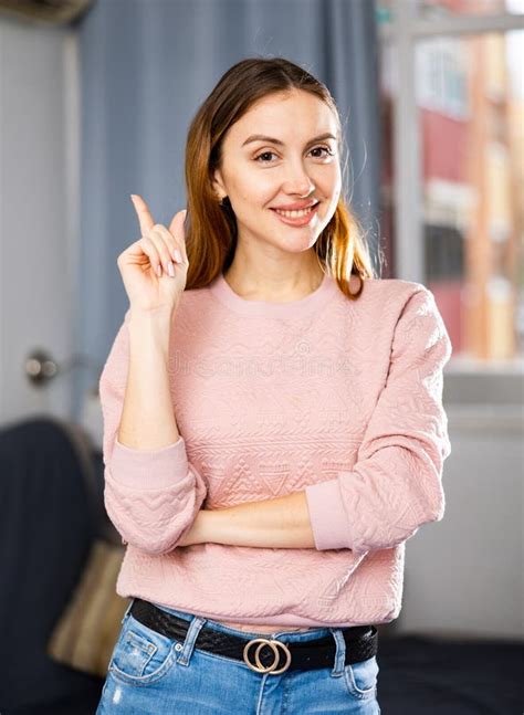 Portrait Of An Emotional Girl Pointing Her Finger At Something In Apartment Stock Photo Image