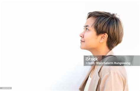 자신감 넘치는 미소와 자세를 가진 아름답고 젊은 아시아 여성의 흰색 배경 측면보기는 현대적인 라이프 스타일에서 캐주얼 드레스를