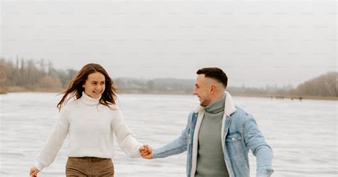 남자와 여자가 물 속을 걷고 있다 사진 Unsplash의 손을 잡고 이미지