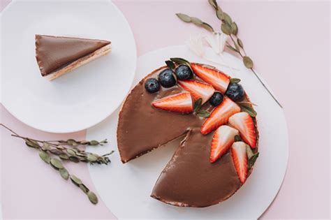 분홍색 배경에 흰색 접시에 조각이 있는 딸기와 포도로 장식된 초콜릿이 있는 새의 밀크 케이크 0명에 대한 스톡 사진 및 기타 이미지 Istock