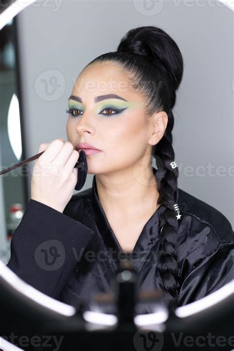 Makeup Artist Holding Brushes And Blending Colors While Creating An