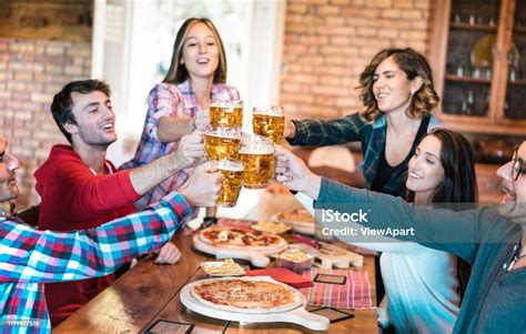 친구 그룹 은 맥주를 마시고 바 레스토랑에서 피자를 먹고 행복한 시간에 리스토 펍 피자 가게에서 함께 재미를 젊은 이들과 우정 개념 파인트 안경에 초점 따뜻한 필터 먹기에