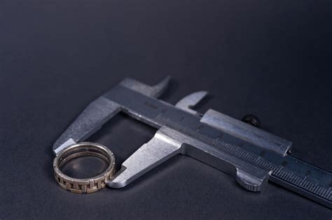 빈티지 스틸 캘리퍼스 측정 스털링 실버 남성 링 근접 촬영 링에 초점을 맞추고 있습니다 아주 좋은 상태에 있는 공구 흐린 회색