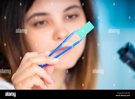 Technician Girl With Microfluidic Device Loc In Microbiological Lab