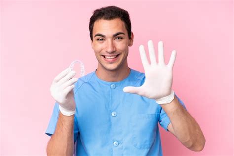 premium photo dentist caucasian man holding invisible braces isolated