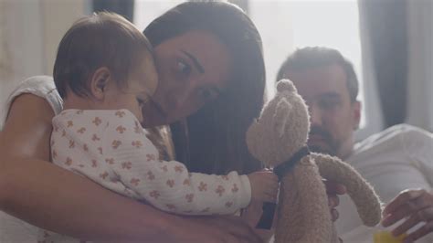 Vídeo Premium Feliz Madre En La Cama Sosteniendo Un Oso De Peluche Y