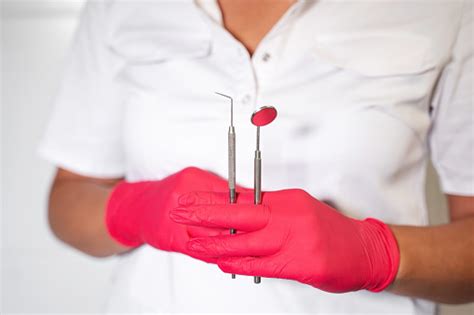 의료용 장갑을 끼고 클로즈업된 치과의사의 손은 치과 도구 거울을 들고 있다 구강 위생 치과 기구 건강 관리 교정 치료