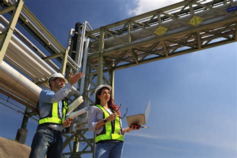 산업 단지의 정유 공장 또는 화학 공장의 파이프라인 건설에서 일하는 여성 및 남성 배관 시스템 엔지니어 2명에 대한 스톡 사진 및 기타 이미지 Istock