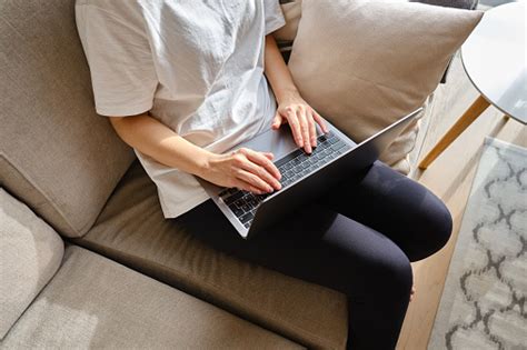 소녀는 집이나 호텔에서 소파에 노트북에서 작동합니다 원격 작업 집에서 사무실 침실에있는 여자는 노트북에 입력 학생들을위한 거리 학습 인터넷 서핑 Brand Name