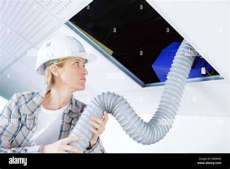 Female Worker Fitting Ventilation System In Buildings Ceiling Stock Photo Alamy