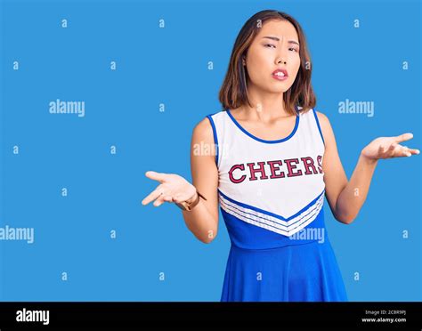 Young Beautiful Chinese Girl Wearing Cheerleader Uniform Clueless And