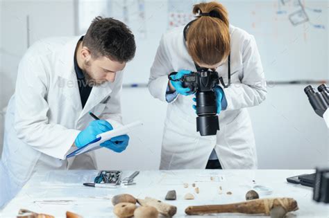 Archaeology Researchers In Laboratory Documenting Artifacts With
