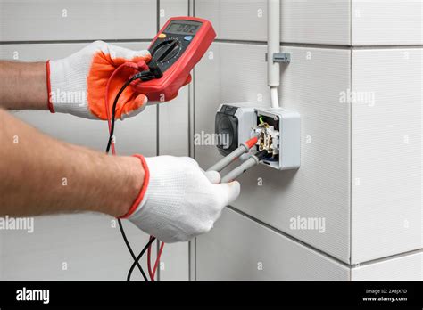 An Electrician Is Using A Multimeter To Measure The Voltage In A Wall Outlet Stock Photo Alamy
