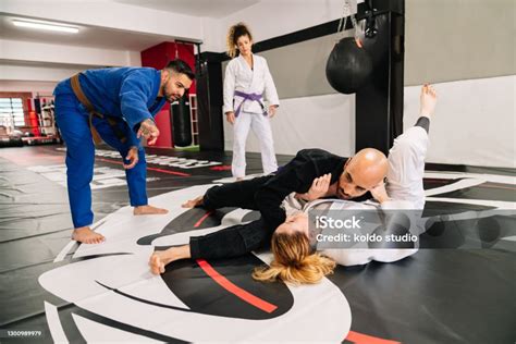 4명의 유도 무술 파트너와 체육관 매트에서 새로운 기술을 연습하는 강사로 구성된 그룹 유도에 대한 스톡 사진 및 기타 이미지 유도 싸우기 십대 Istock