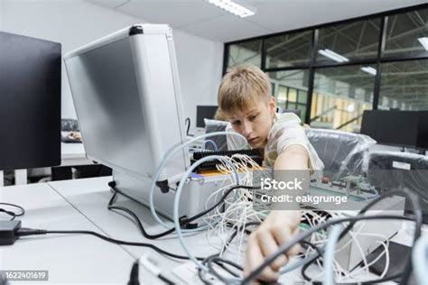 전기 제품 수리를 배우는 소년 교실에서 탁자 교육 로봇 학습 혁신 전기 시스템 기술 훈련 Stem 교육 개념입니다 12 13세에