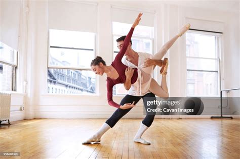 Full Length Of Graceful Male And Female Ballet Dancers Performing In