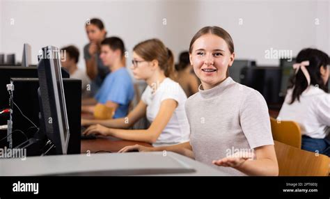 Excited Female Teenager Learning Computer Science While She Is Using A PC In The Computer