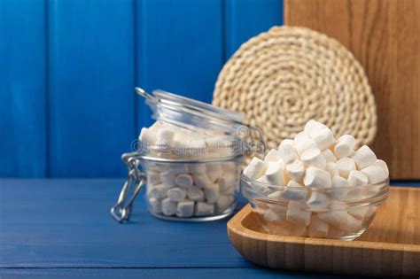Many Different Marshmallows In Bowls And Jars On Textured Wood Stock