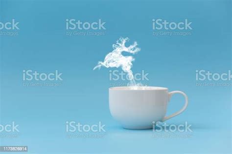 커피 컵에서 날아 오는 순록 모양의 증기 아침 음료 크리스마스 또는 새해 축하 개념입니다 공간을 복사합니다 연기 물리적 구조에