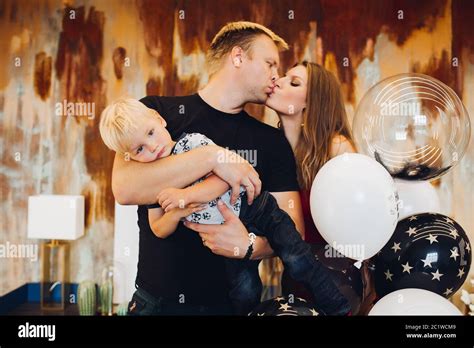 Happy Father And Mother Kissing While Man Holding Son In Hands Stock Photo Alamy