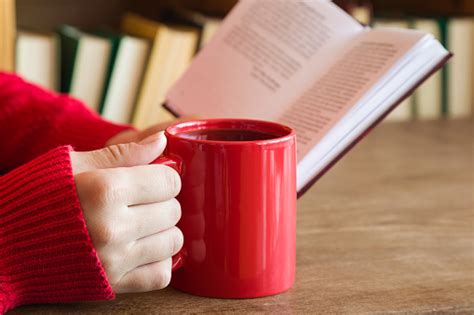 젊은 여자를 휴식 하 고 도서관에서 커피 한잔과 함께 읽는 책을 즐기는 온난 하 고 평화로운 분위기입니다 가정 생활에 대한 스톡 사진 및 기타 이미지 Istock