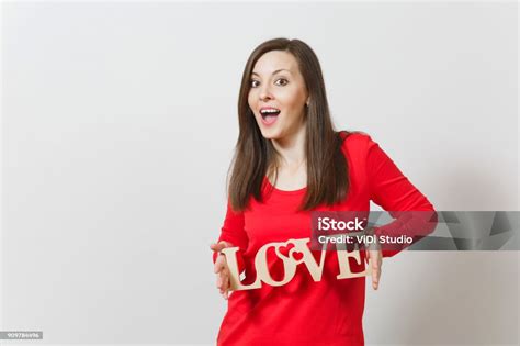 아름 다운 젊은 갈색 머리 재미 빨간색 캐주얼 옷 흰색 배경에 나무 말씀 사랑을 들고 여자를 웃 고 광고에 대 한 공간을 복사 합니다 성 발렌타인의 날 또는 국제 여성의 날