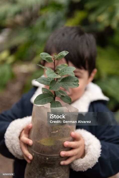 알아볼 수 없는 소년은 플라스틱 병으로 만든 화분에 식물을 들고 Esg 환경 지구의 날 지속 가능성 세계 환경의 날을 개념으로 합니다 가정에서의 재활용과 지속 가능성의 개념