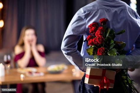 로맨틱 한 검정 남자 들고 꽃과 선물 뒤에 뒤에 놀라운 그의 여자 친구 밸런타인데이에 대한 스톡 사진 및 기타 이미지 밸런타인데이 저녁 식사 2명 Istock