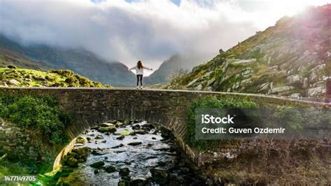 아일랜드의 갭 오브 던로 카운티 케리 오래된 돌다리에서 자연을 보는 여자 자연 속에서 자유롭고 자연에서 강한 여자 자연에 경의를 표하는 여자 영화 같은 자연 사진 휴식 명상