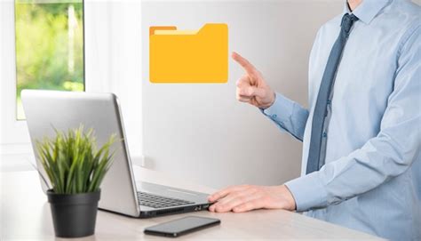 사업가가 폴더 아이콘을 잡고 있습니다 It 컨설턴트가 최신 컴퓨터를 사용하여 설정한 문서 관리 시스템 또는 Dms가 관리 정보 및 회사 파일을 검색하고 있습니다 비즈니스