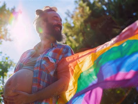 Happy Expectant Pregnant Transgender Man Cradling Stomach At Pride