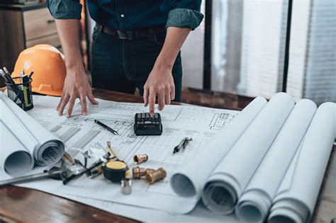 사무실 책상과 삼각형 눈금자 안전 안경 나침반 블루프린트의 버니어 캘리퍼에서 도면 검사 및 프레스 계산기로 작업하는 엔지니어링 엔지니어 건축가 산업 및 공장 개념 35 39