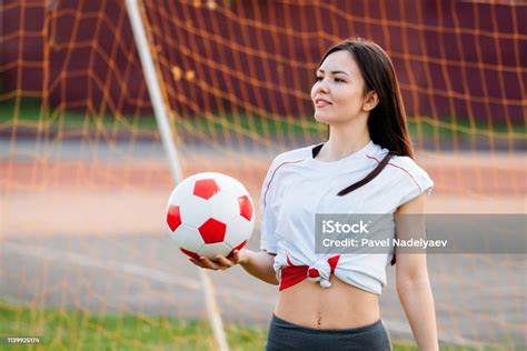 스포츠웨어에서 아름 다운 젊은 체육 여성이 축구 목표의 배경에 경기장에서 훈련입니다 축구 그녀는 행복 하 고 웃는 가냘픈에 대한