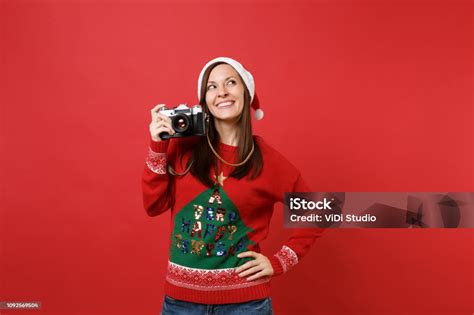 크리스마스 모자 올려 고 빨간색 배경에 고립 된 복고풍 빈티지 사진 카메라를 들고 꽤 메리 젊은 산타 소녀 행복 한 새 해 2019 축 하 휴일 파티 개념입니다 복사 공간을