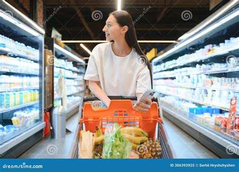 Female Customer Uses Mobile Phone In Supermarket Stock Image Image Of Basket Grocery 306393925